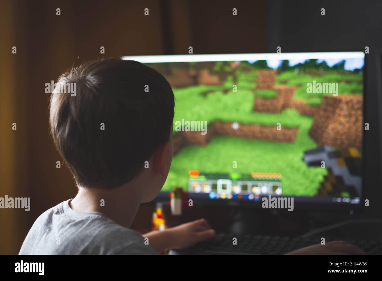 The boy plays minecraft. Computer games at home. Construction in the ...