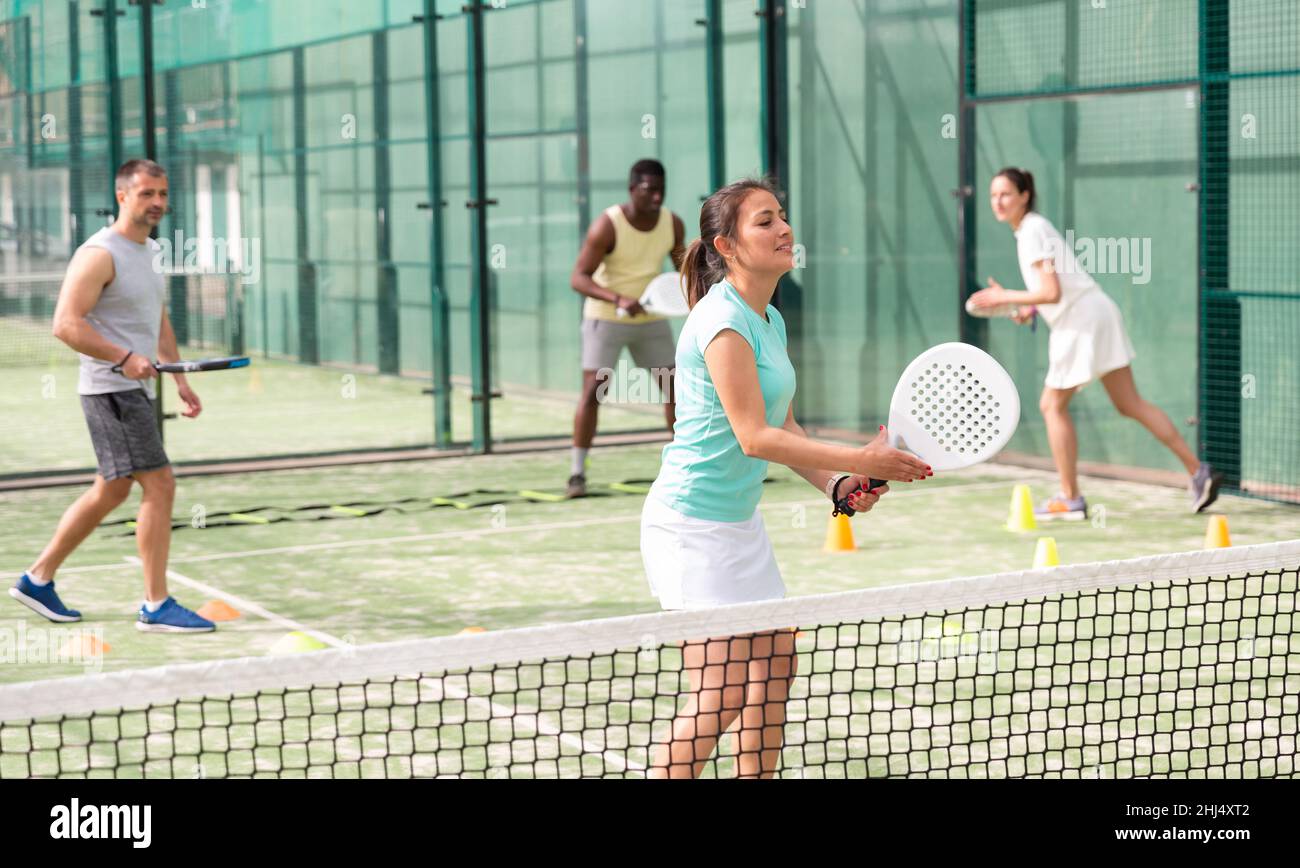 Training while playing on tennis court. Woman learning to play paddle ...