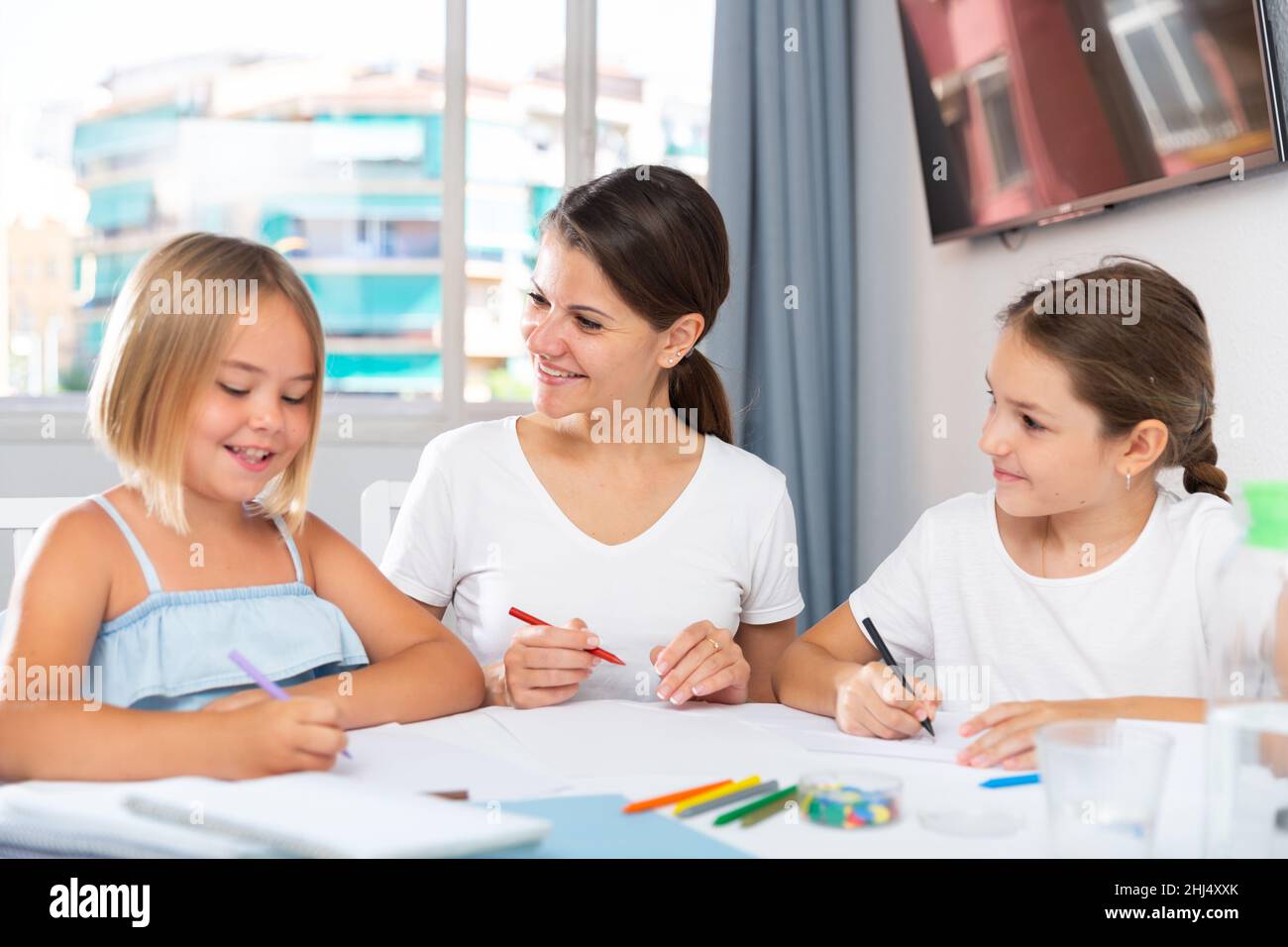Young woman and two daughters drawing together Stock Photo - Alamy