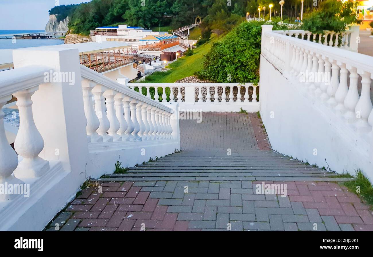 Classic white balustrade along the steps leading to the seashore, a ...