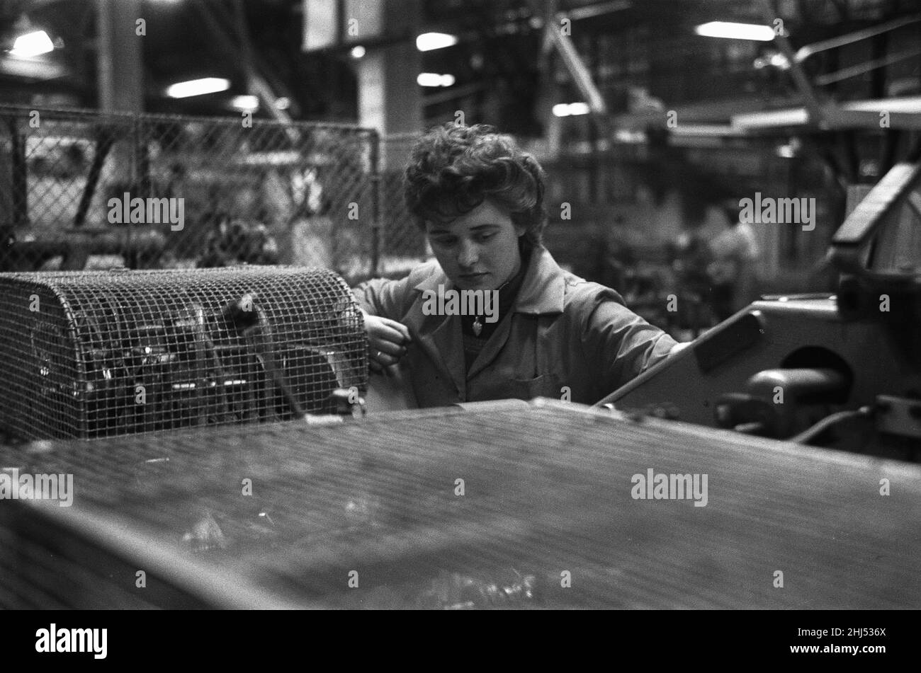 A young female employee checks that the machine has correctly filled ...