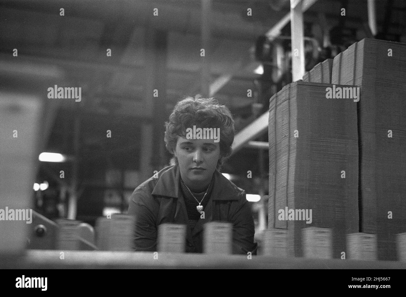 A young female employee checks that the machine has correctly filled ...