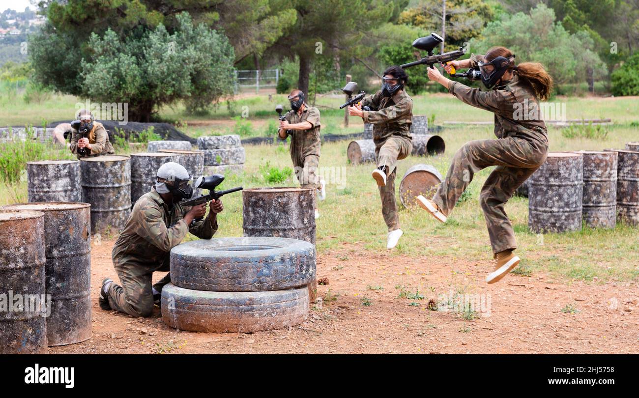 Group of friends paintball players of opposite teams in shootout in ...