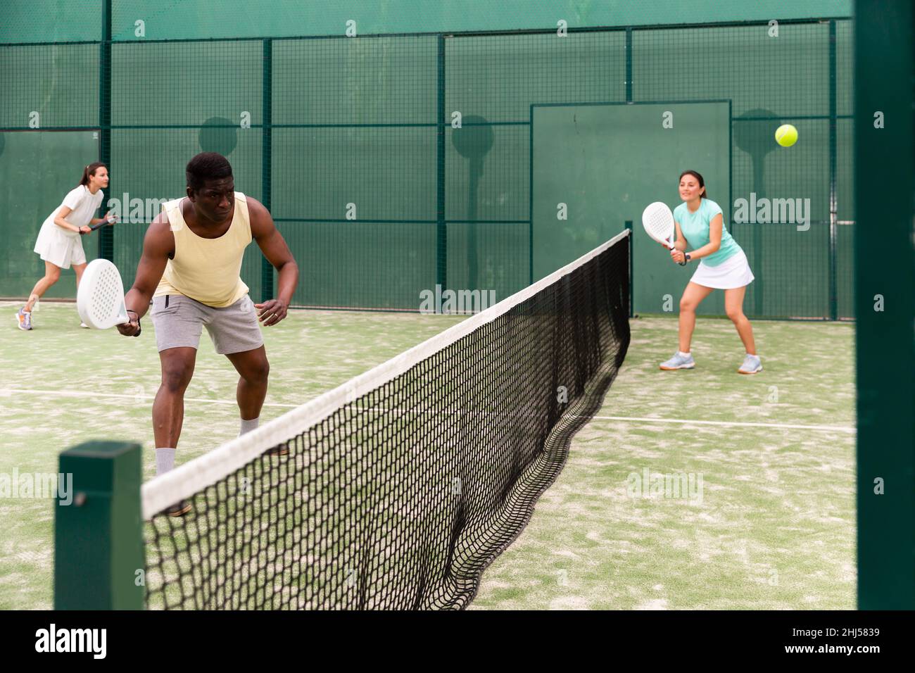 Positive young adult people playing paddle tennis Stock Photo - Alamy