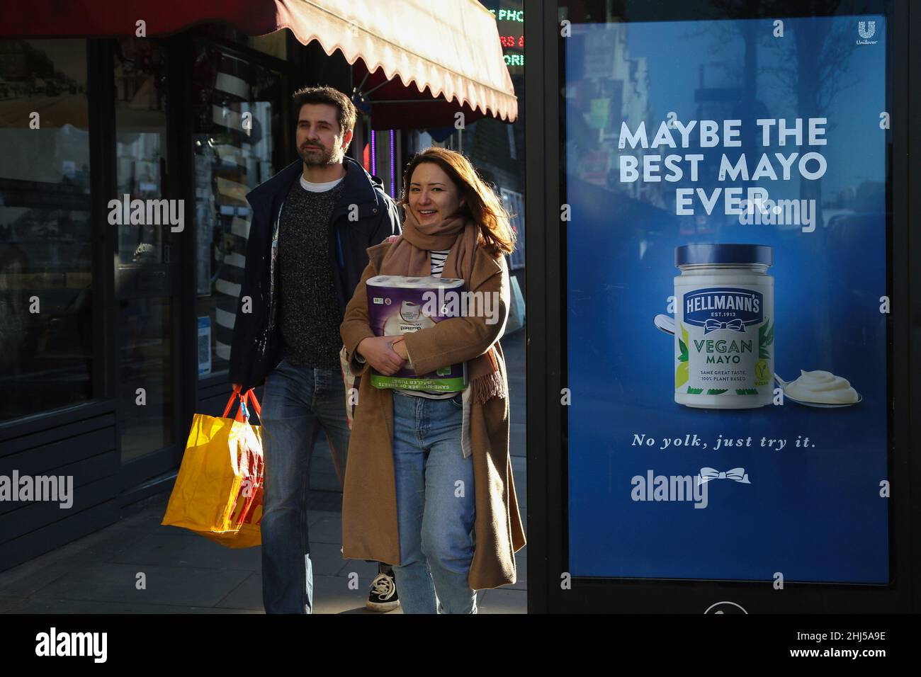 A couple walk past Hallmann's Vegan Mayo's digital advert Stock Photo ...