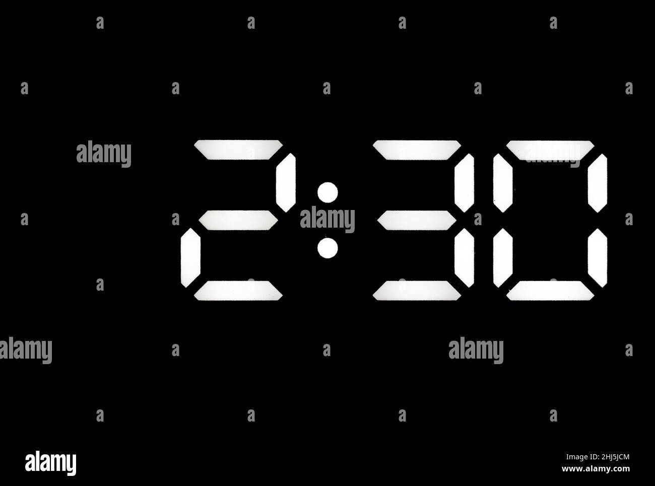 Real white led digital clock on a black background showing time 2:30 ...