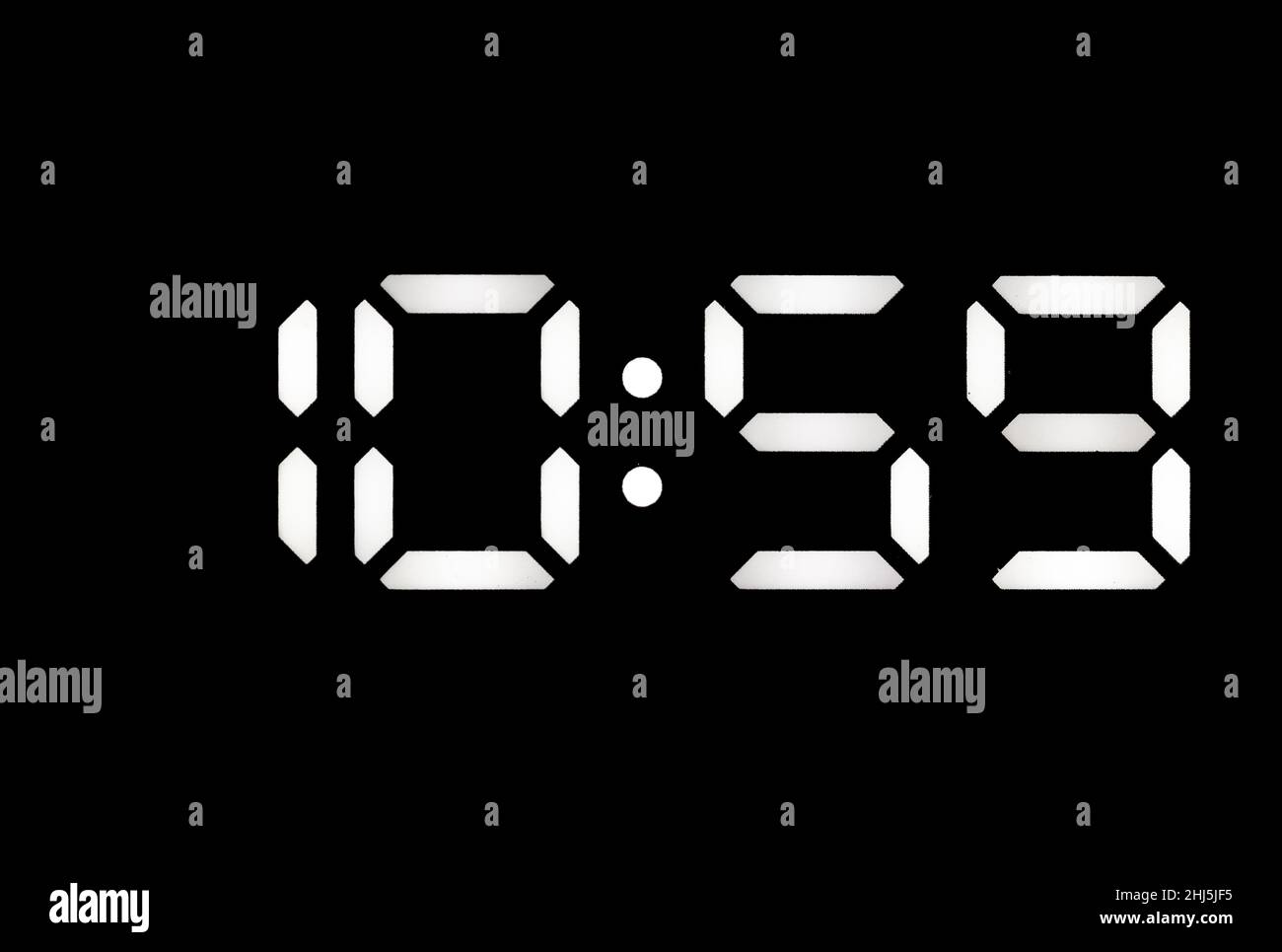 Real white led digital clock on a black background showing time 10:59 ...
