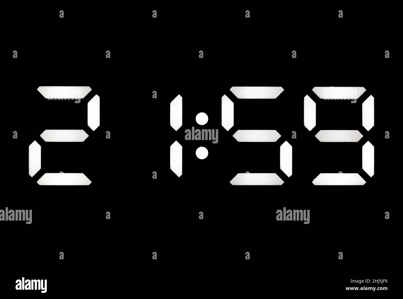 Real white led digital clock on a black background showing time 21:59 ...