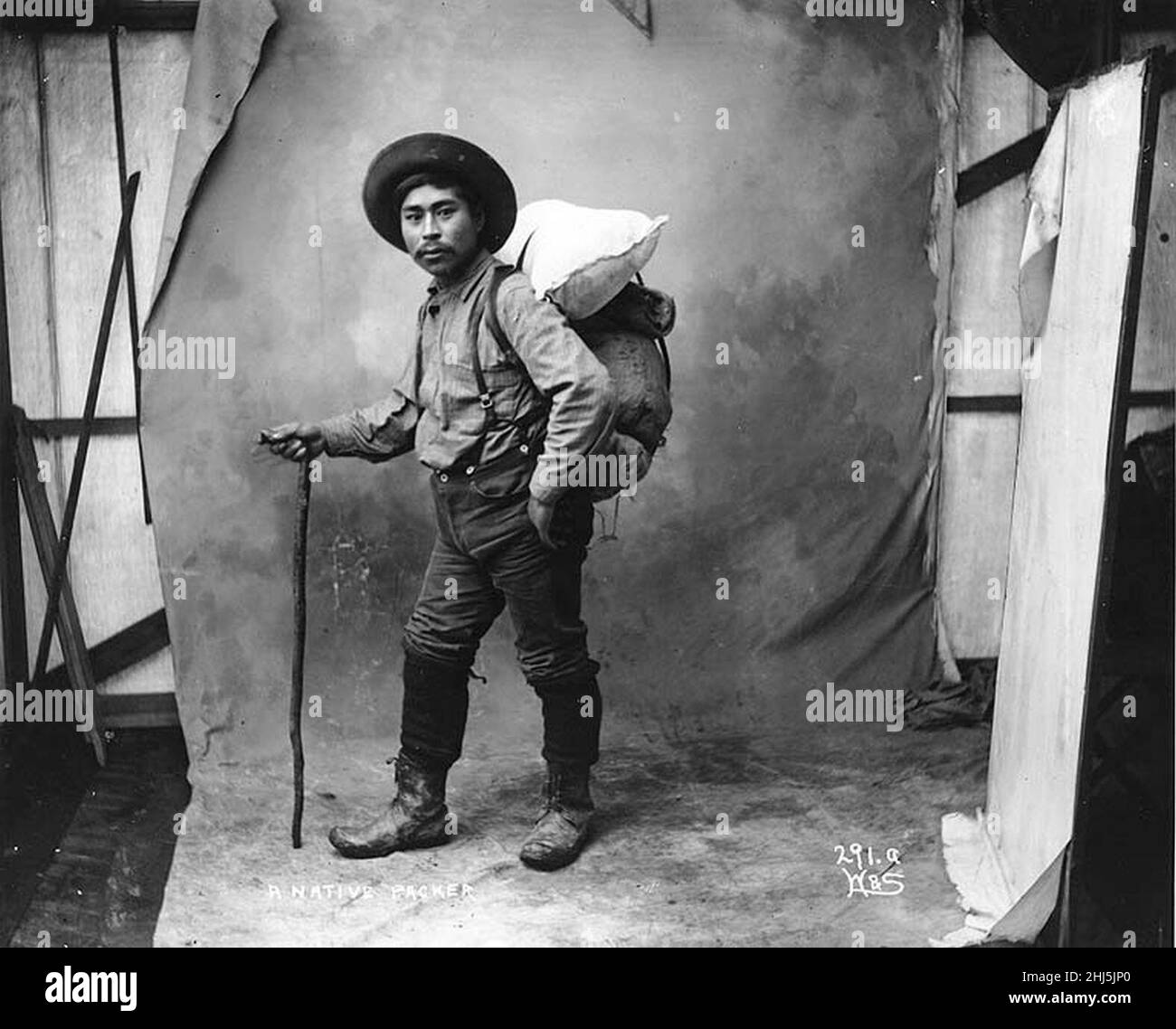 Studio portrait of a Chilkat Indian posed as a packer for the Klondike ...