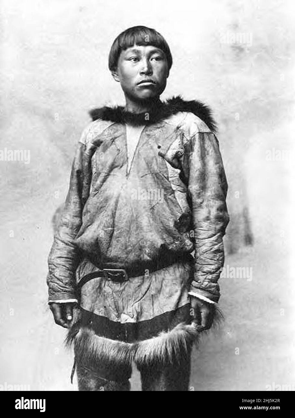 Studio portrait of young Eskimo man in skin parka with fur trim, Nome ...