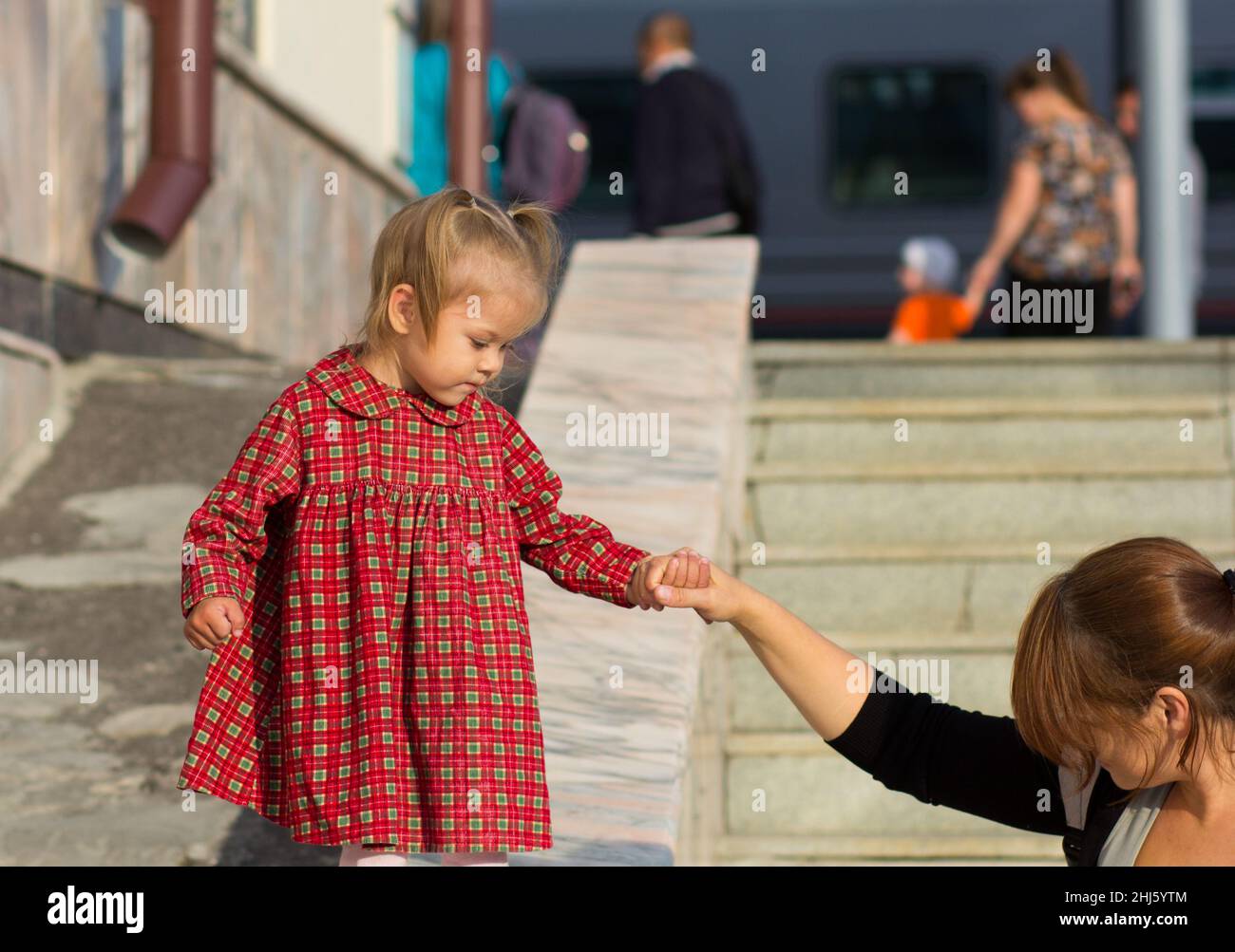Caucasian child of two years old holding mother hand waiting support to ...