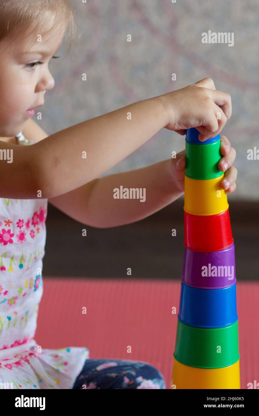 Caucasian little girl of three years old building pyramid using ...