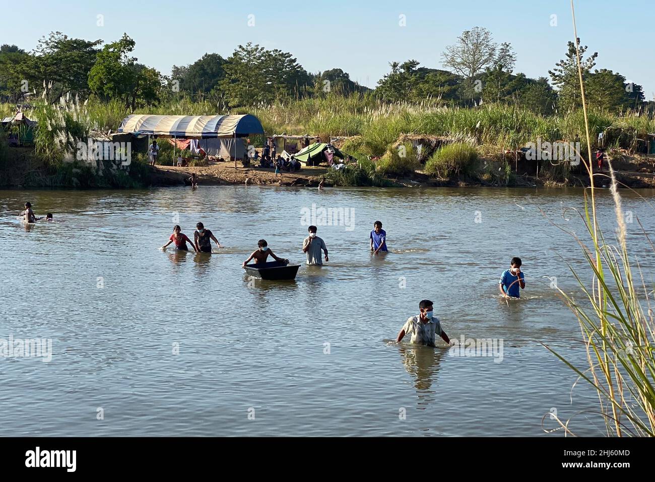 Mae Sot, Thailand. 20th Jan, 2022. Refugees wade through the Moei River ...