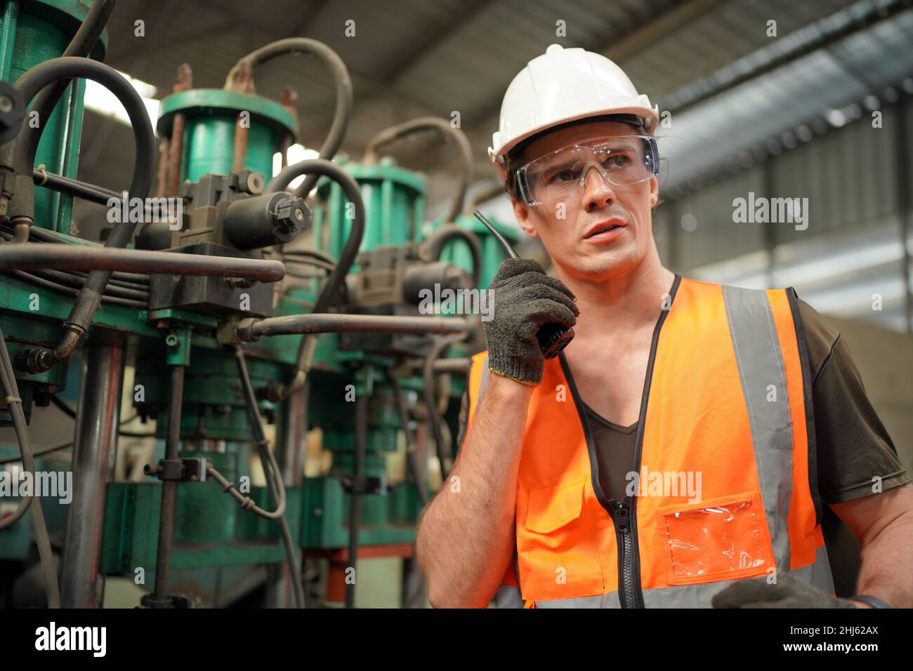 Professional engineer metalworker operating CNC milling machine center ...