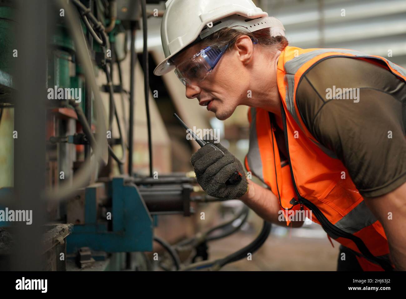 Professional engineer metalworker operating CNC milling machine center ...