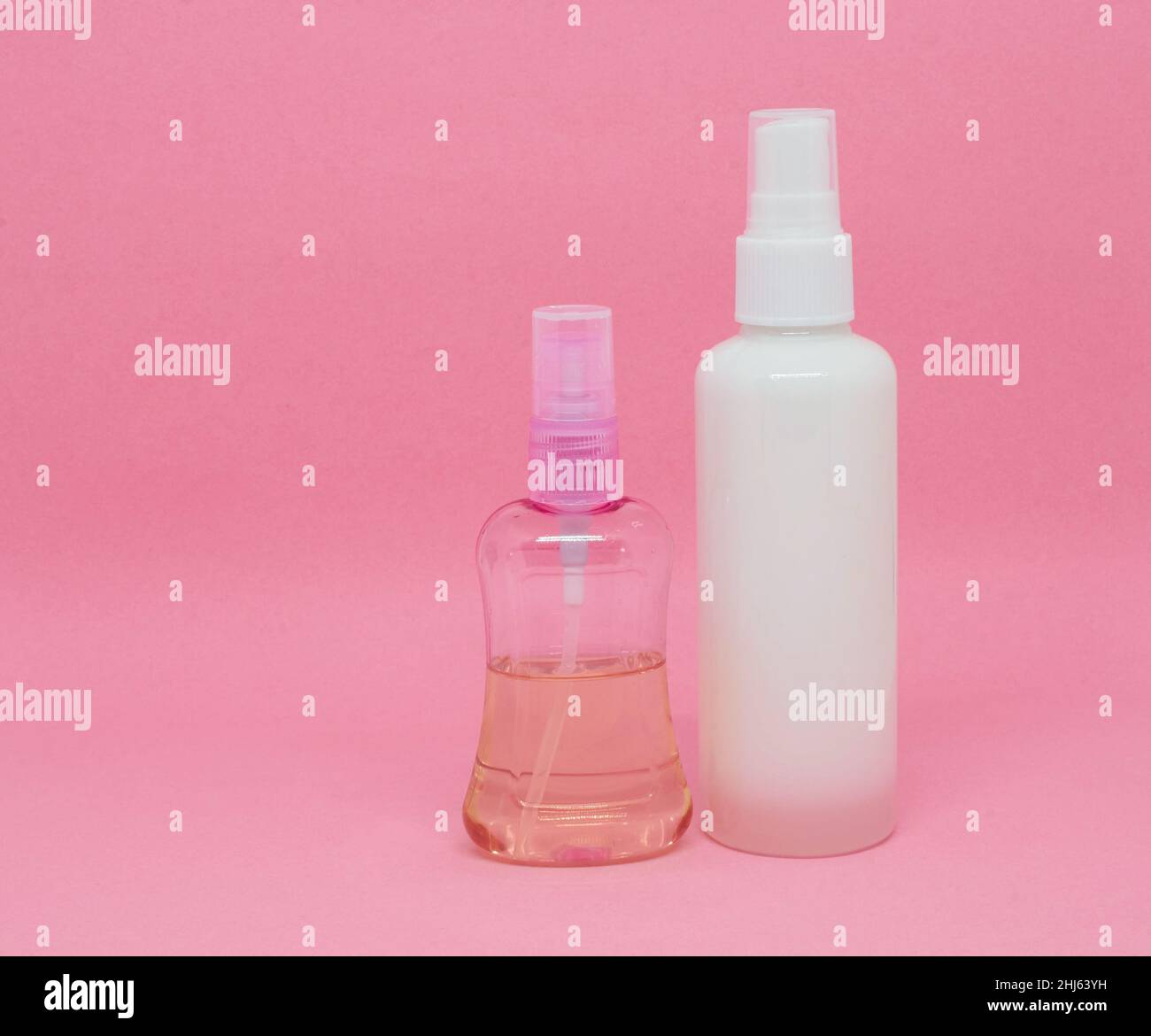 Two spray bottles on a pink background Stock Photo - Alamy