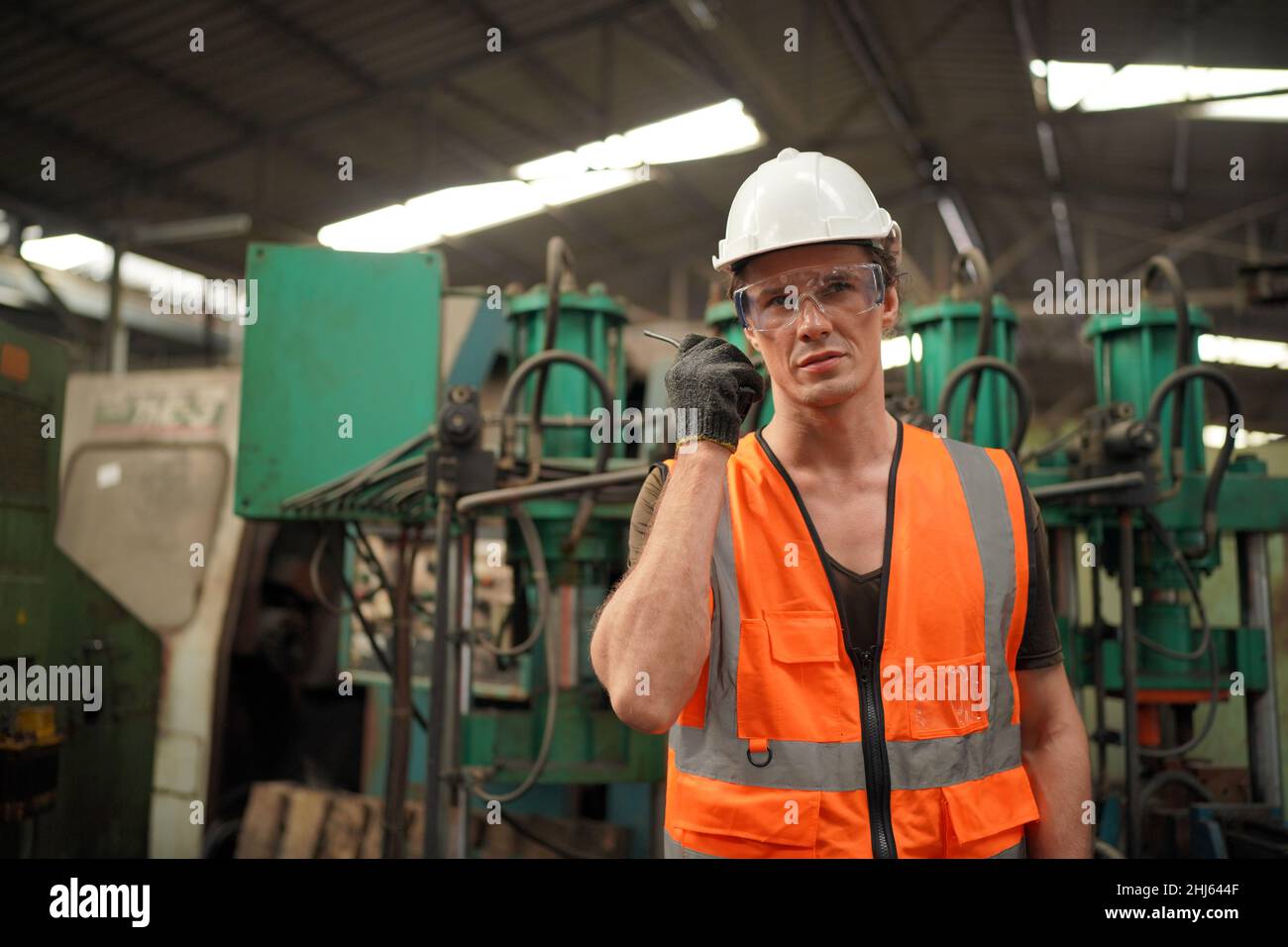 Professional engineer metalworker operating CNC milling machine center ...