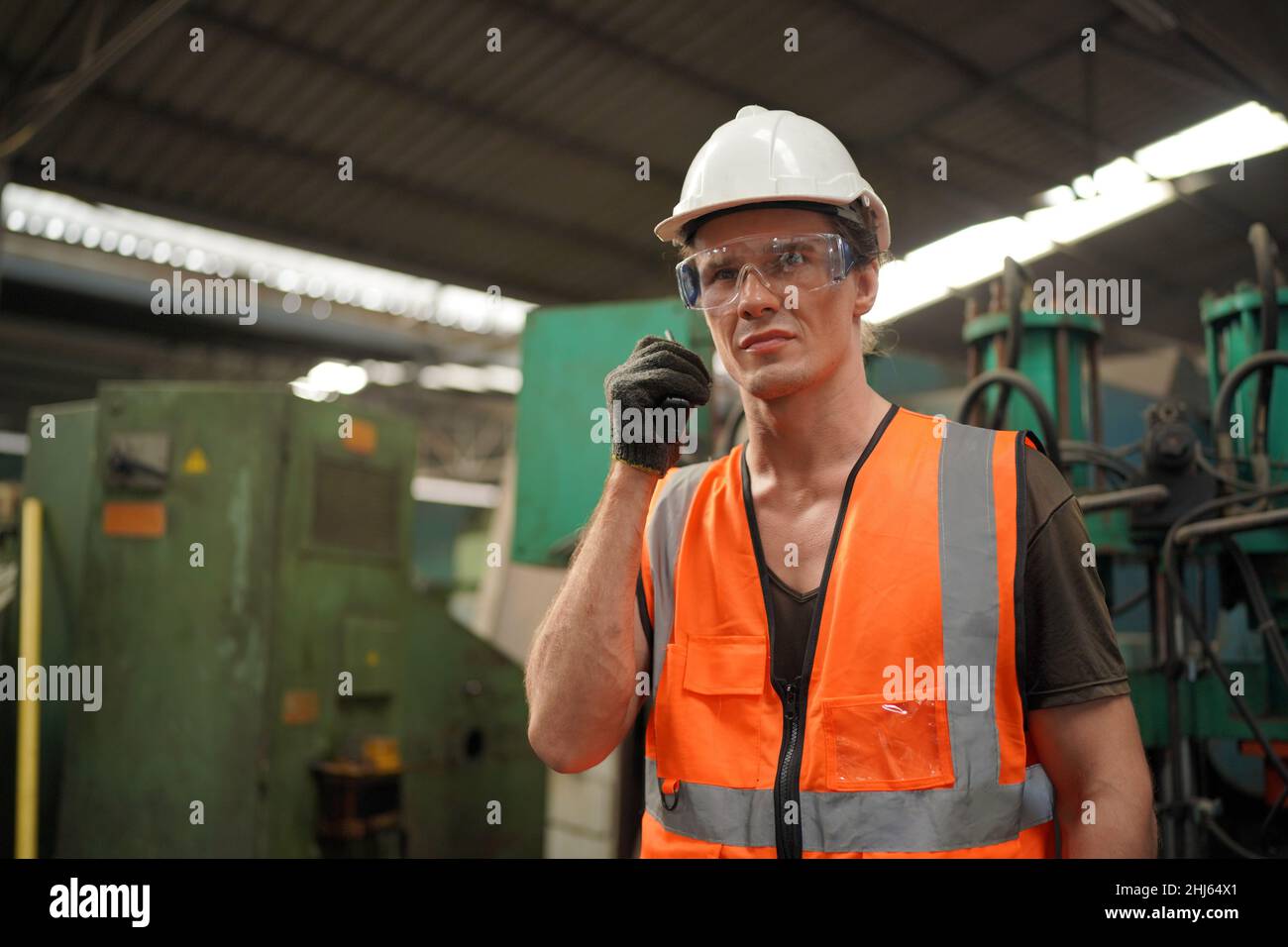 Professional engineer metalworker operating CNC milling machine center ...