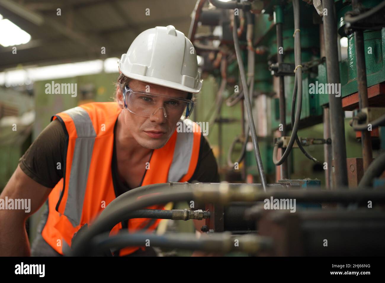 Professional engineer metalworker operating CNC milling machine center ...