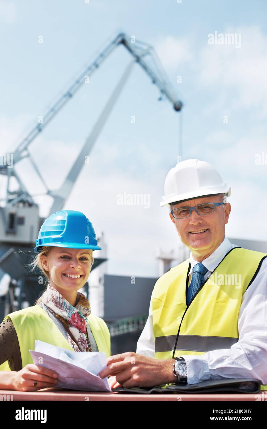 The mentor hands over the reigns. Two dock workers holding paperwork ...