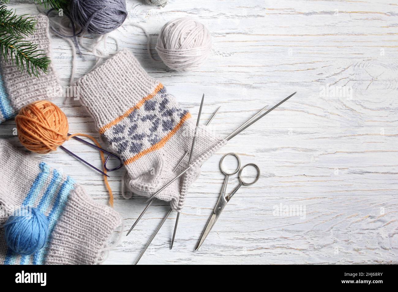 Flat lay of knitting and winter accessories on white wooden background ...