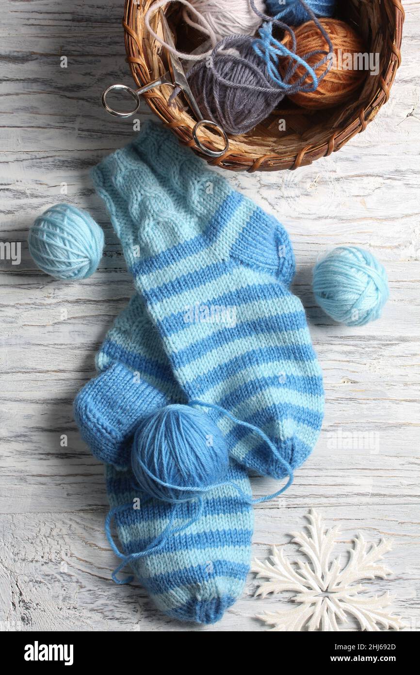 Flat lay of knitting and winter accessories on white wooden background ...
