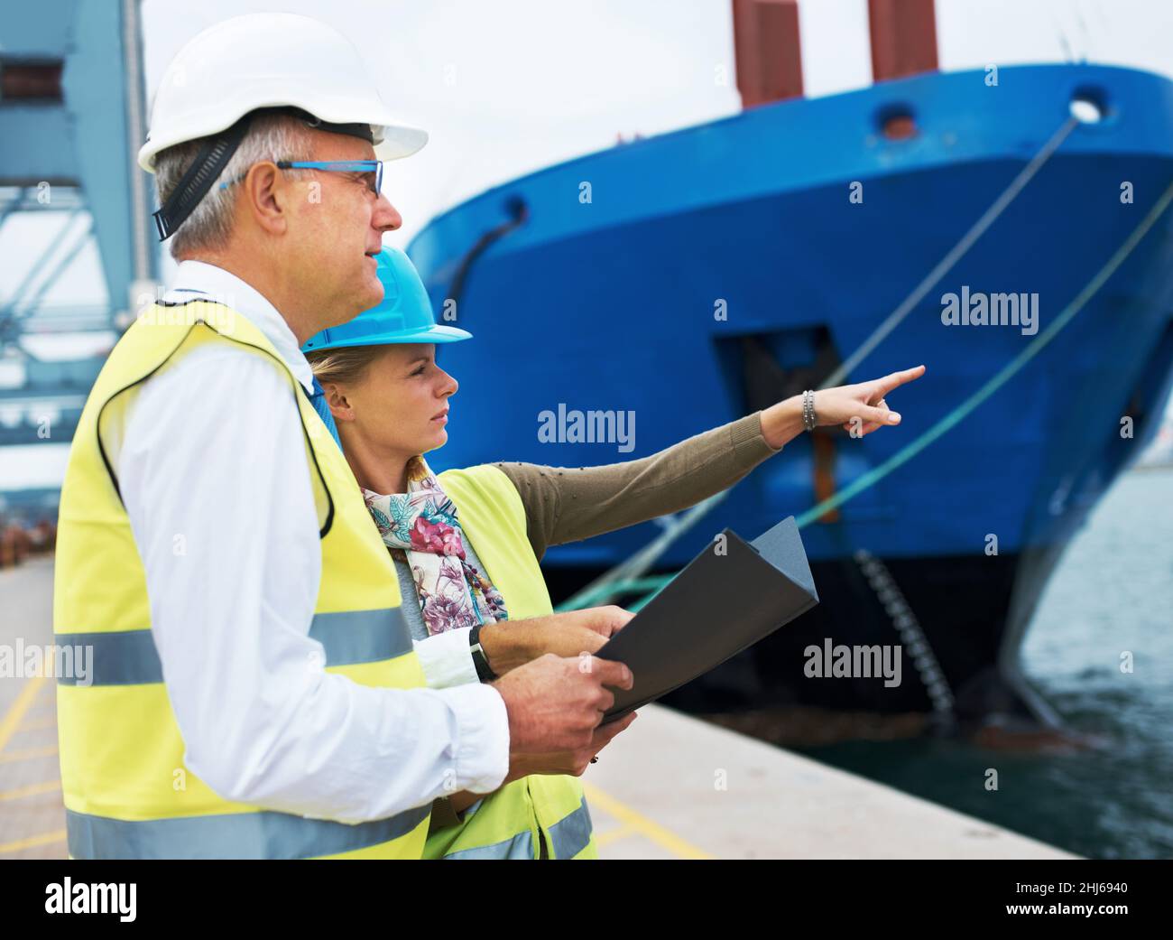 Ship hunt. Two dock workers conferring among themselves while surveying ...