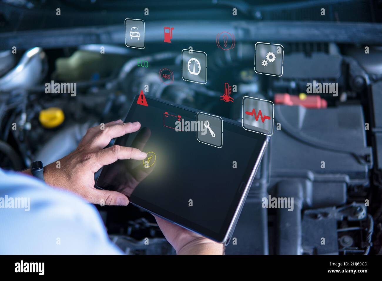 Auto mechanic with digital tablet at work making an engine repair ...