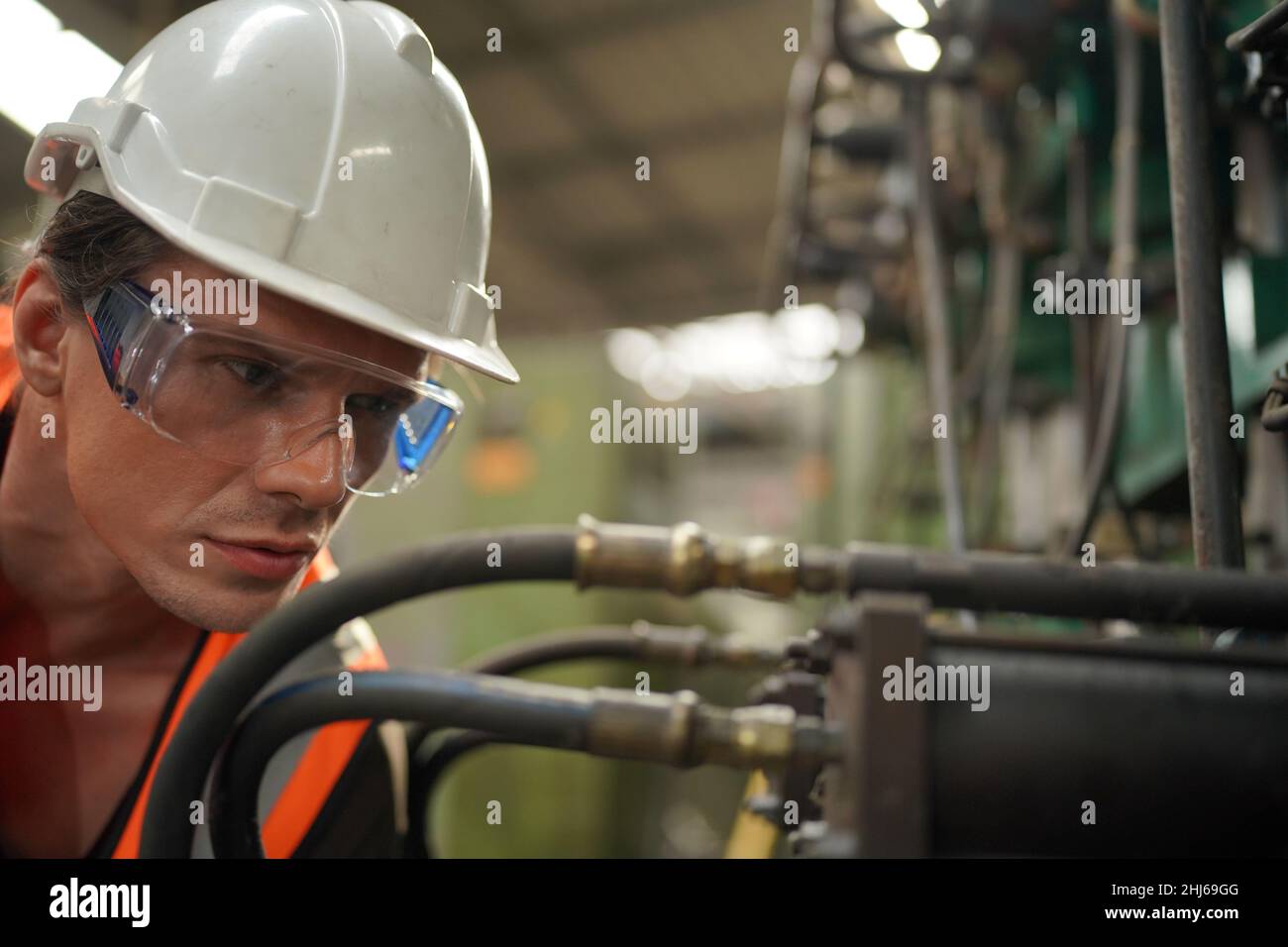 Professional engineer metalworker operating CNC milling machine center ...