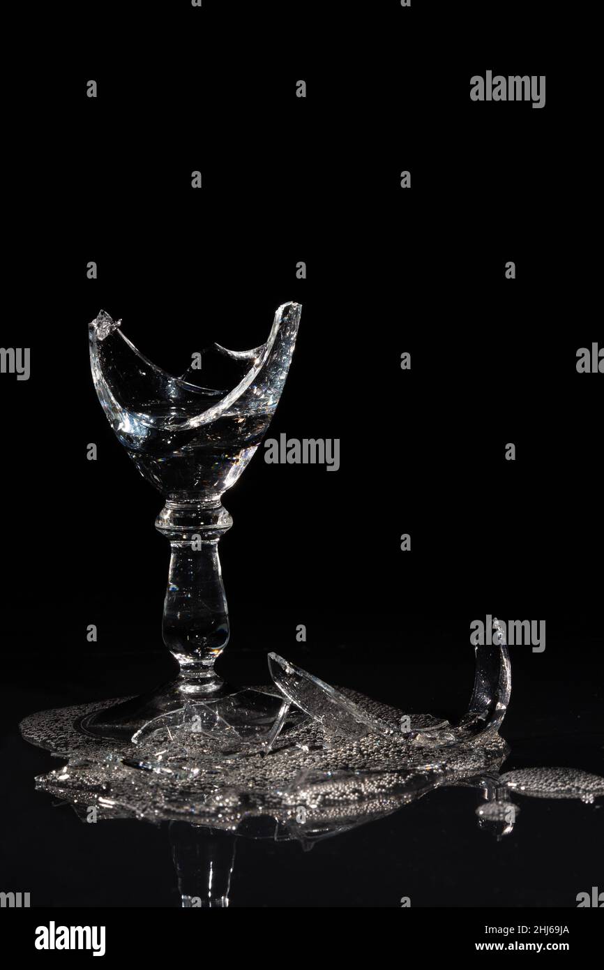 Broken wine glass and spilled wine on black background Stock Photo - Alamy