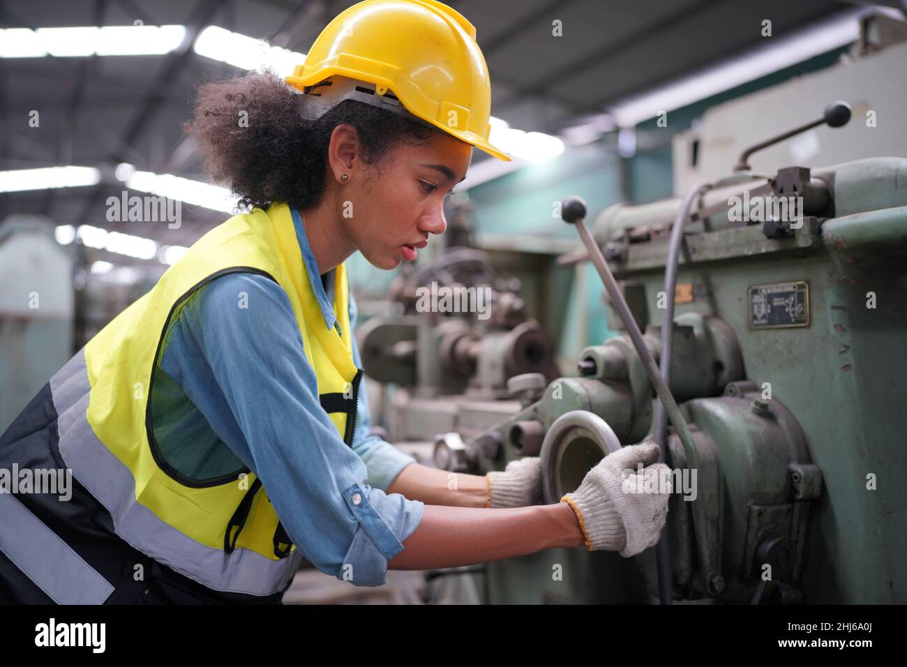 Female apprentice in metal working factory, Portrait of working female ...