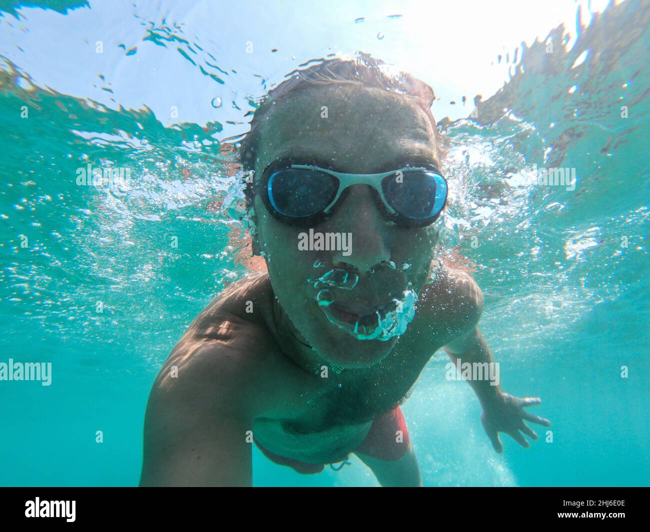 Funny guy having fun and taking underwater selfie while swimming in the ...