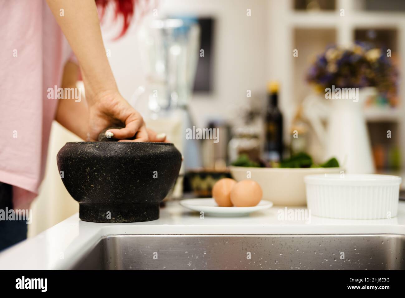 Black woman spice mortar while cooking in kitchen at home Stock Photo ...