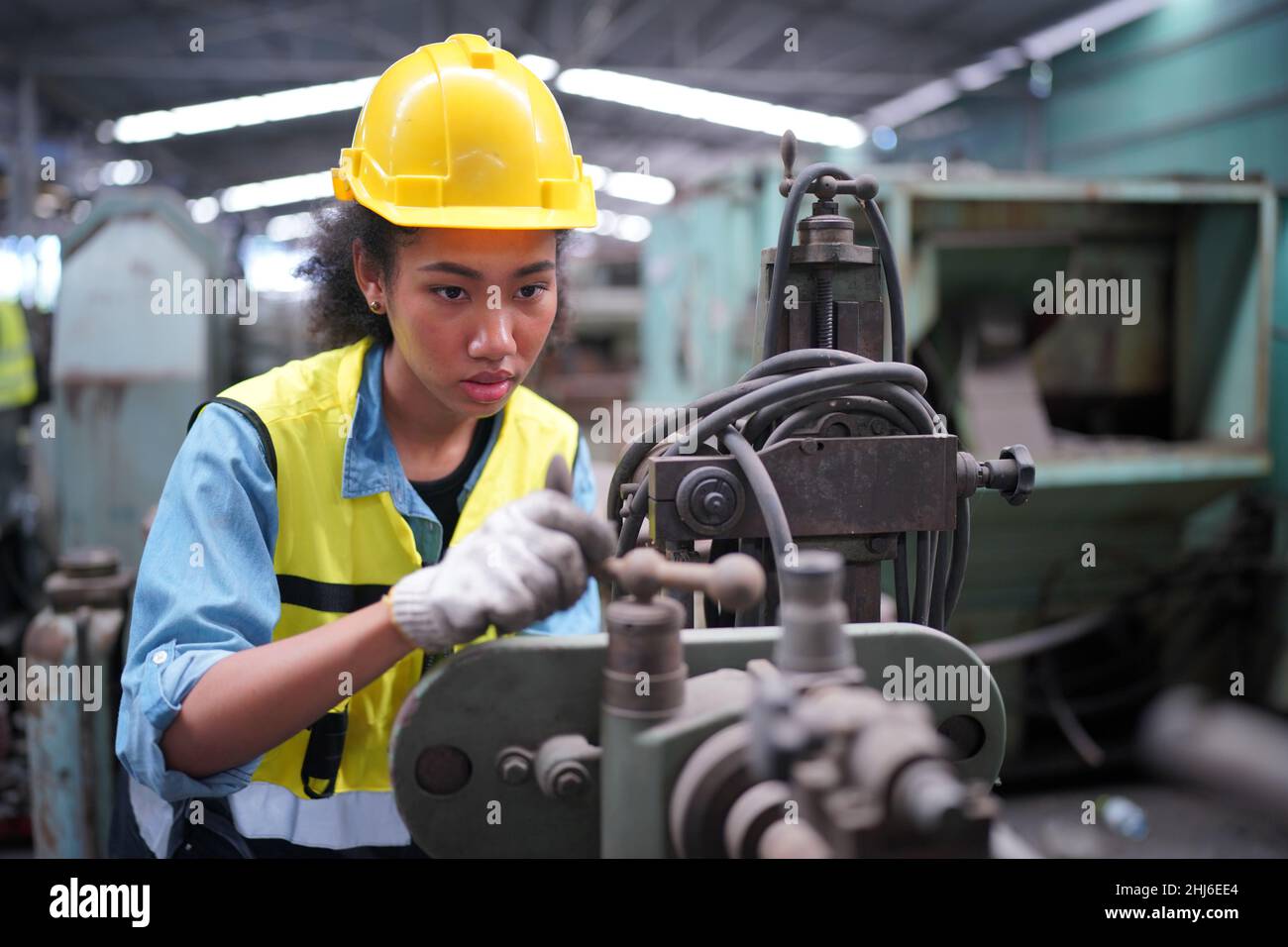 Female apprentice in metal working factory, Portrait of working female ...