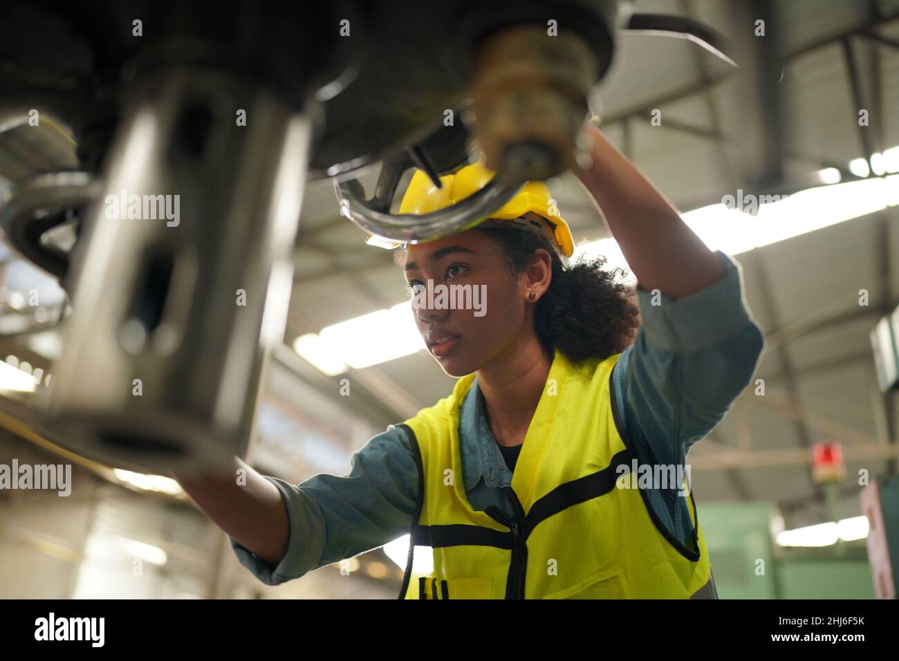 Female apprentice in metal working factory, Portrait of working female ...