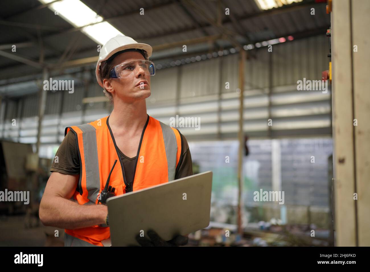 Professional engineer metalworker operating CNC milling machine center ...