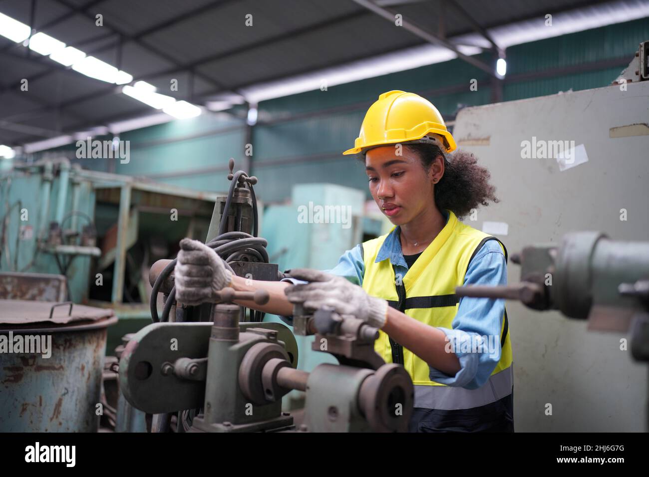 Female apprentice in metal working factory, Portrait of working female ...