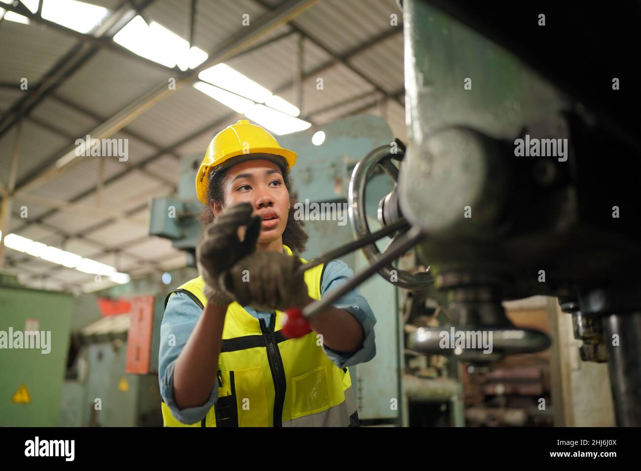 Female apprentice in metal working factory, Portrait of working female ...