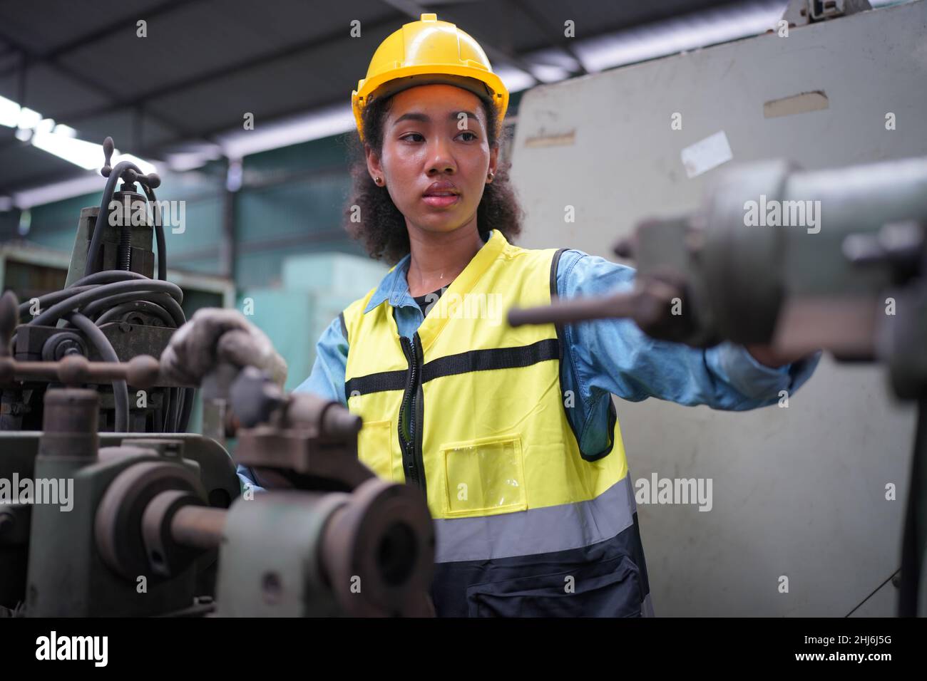 Female apprentice in metal working factory, Portrait of working female ...