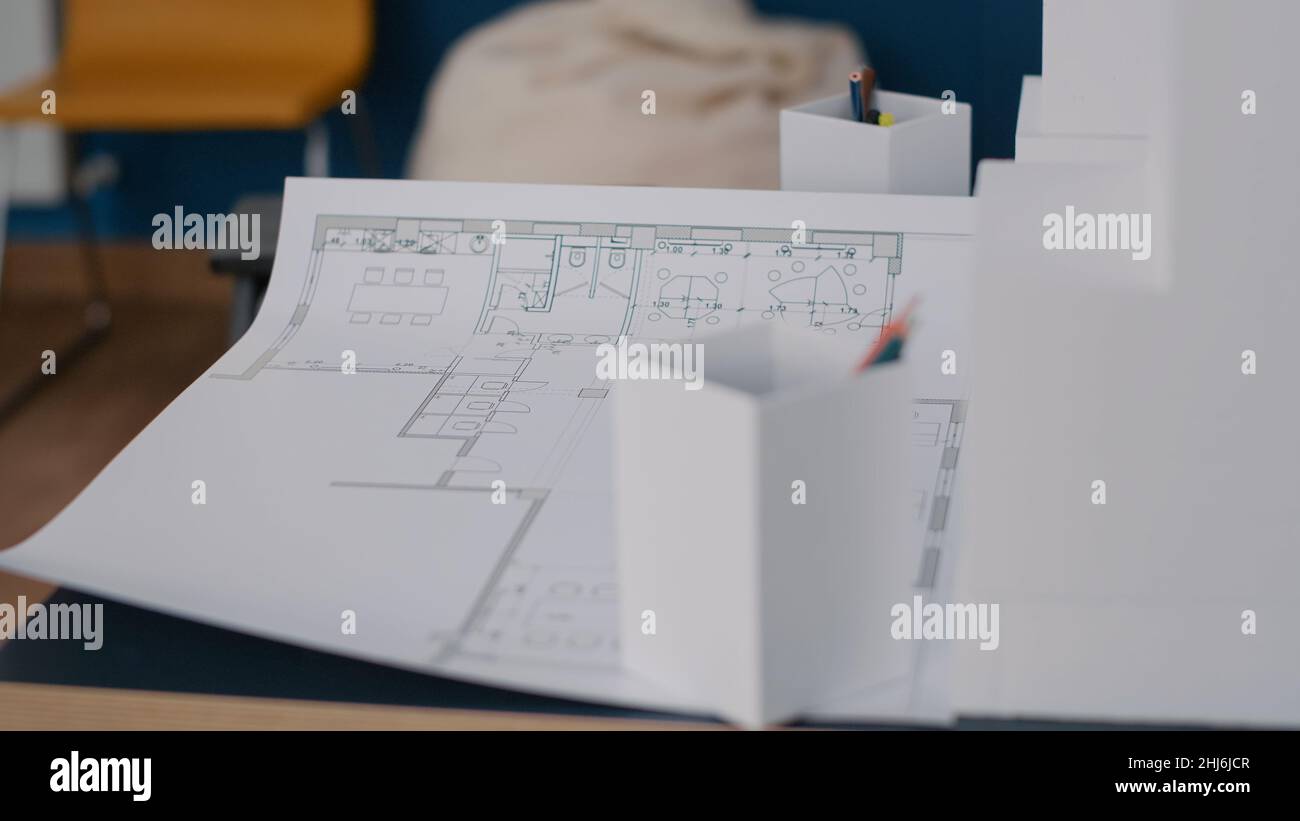 Close up of paper with blueprints plans on table in architectural ...