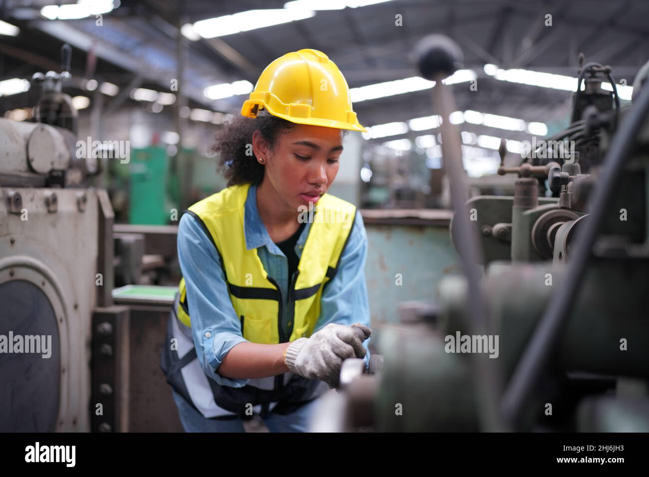 Female apprentice in metal working factory, Portrait of working female ...