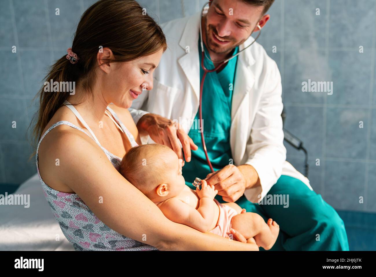 Happy pediatrician doctor with baby checking possible heart defect ...