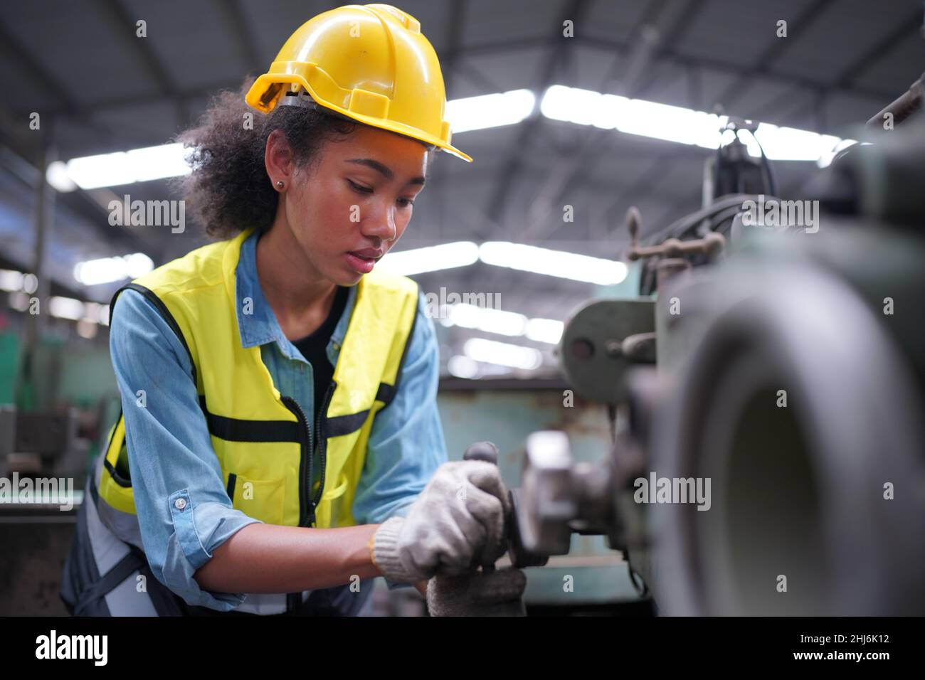 Female apprentice in metal working factory, Portrait of working female ...