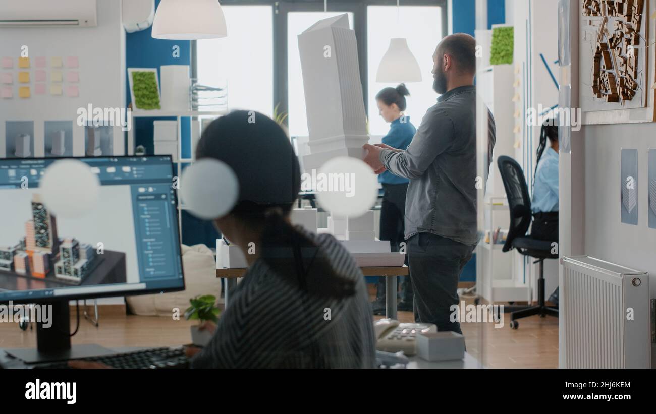 Architect Analyzing Building Model And Maquette In Architectural Office To Design Construction