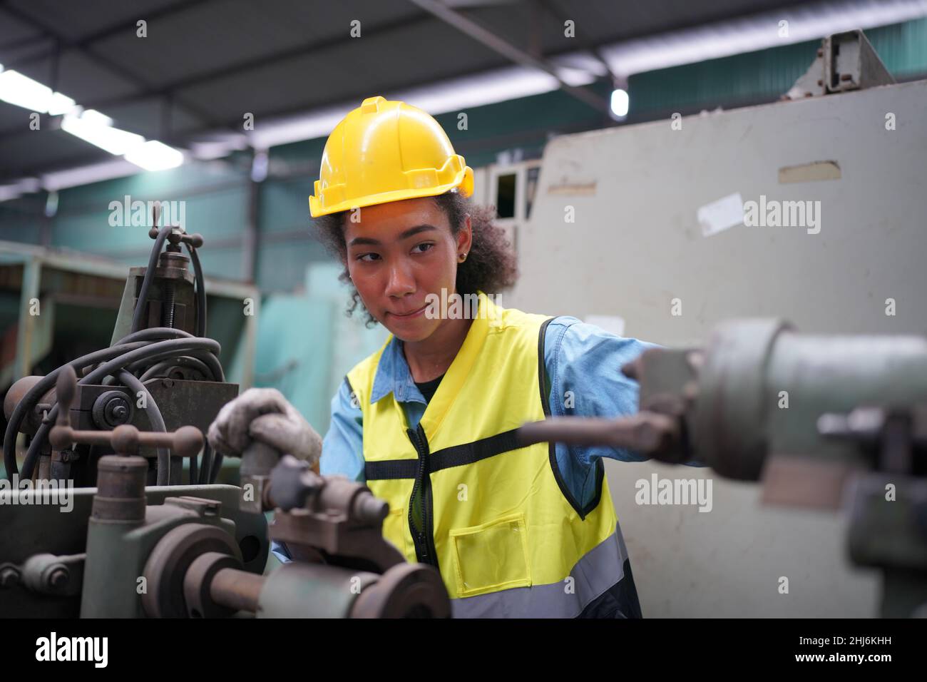 Female apprentice in metal working factory, Portrait of working female ...