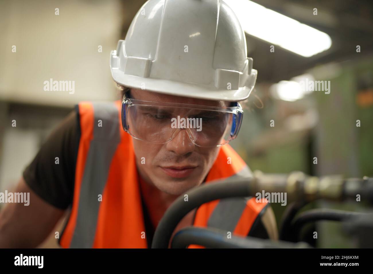 Professional engineer metalworker operating CNC milling machine center ...