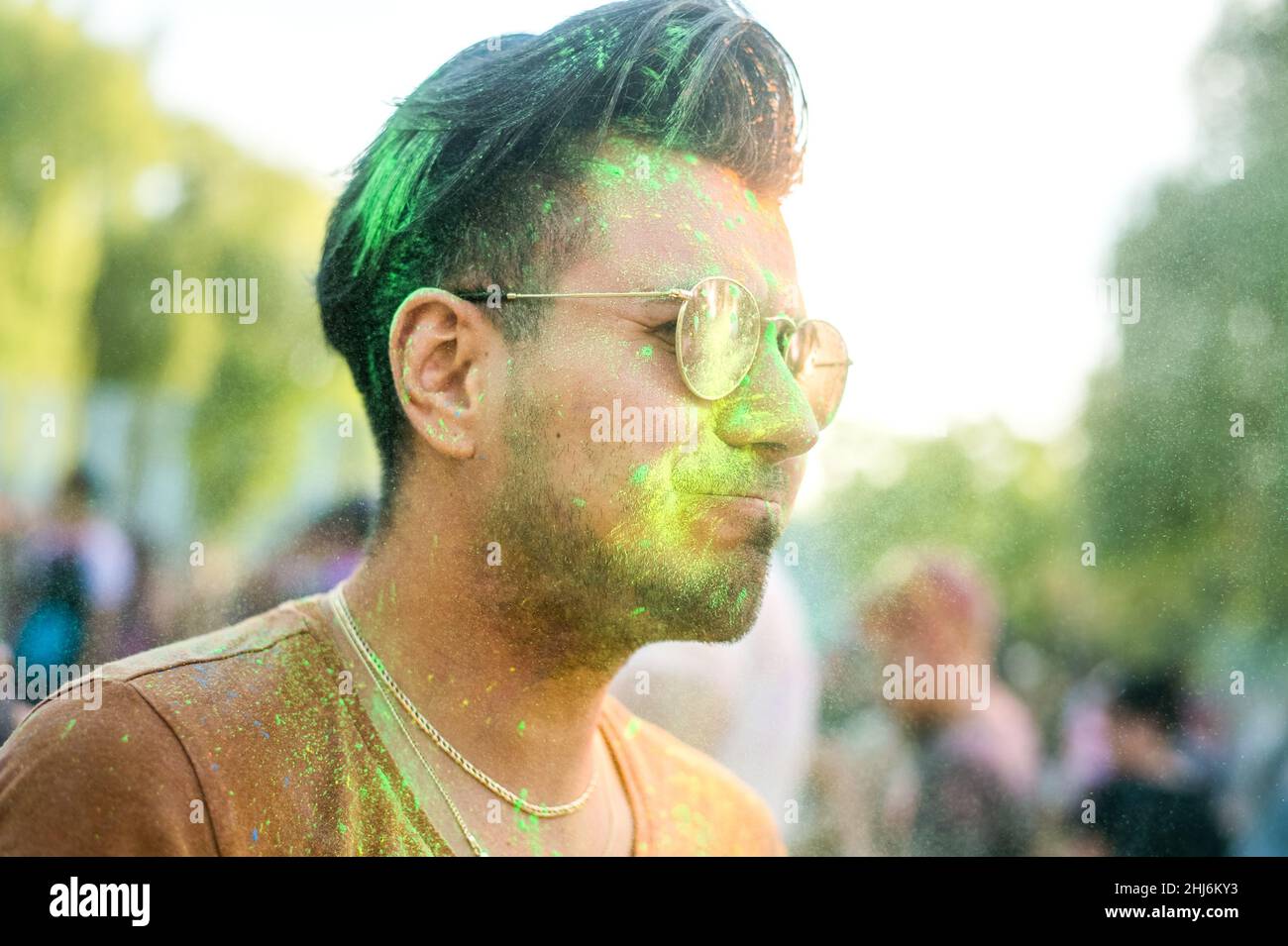 handsome smiling black hair man with colorful face having fun on Holi ...