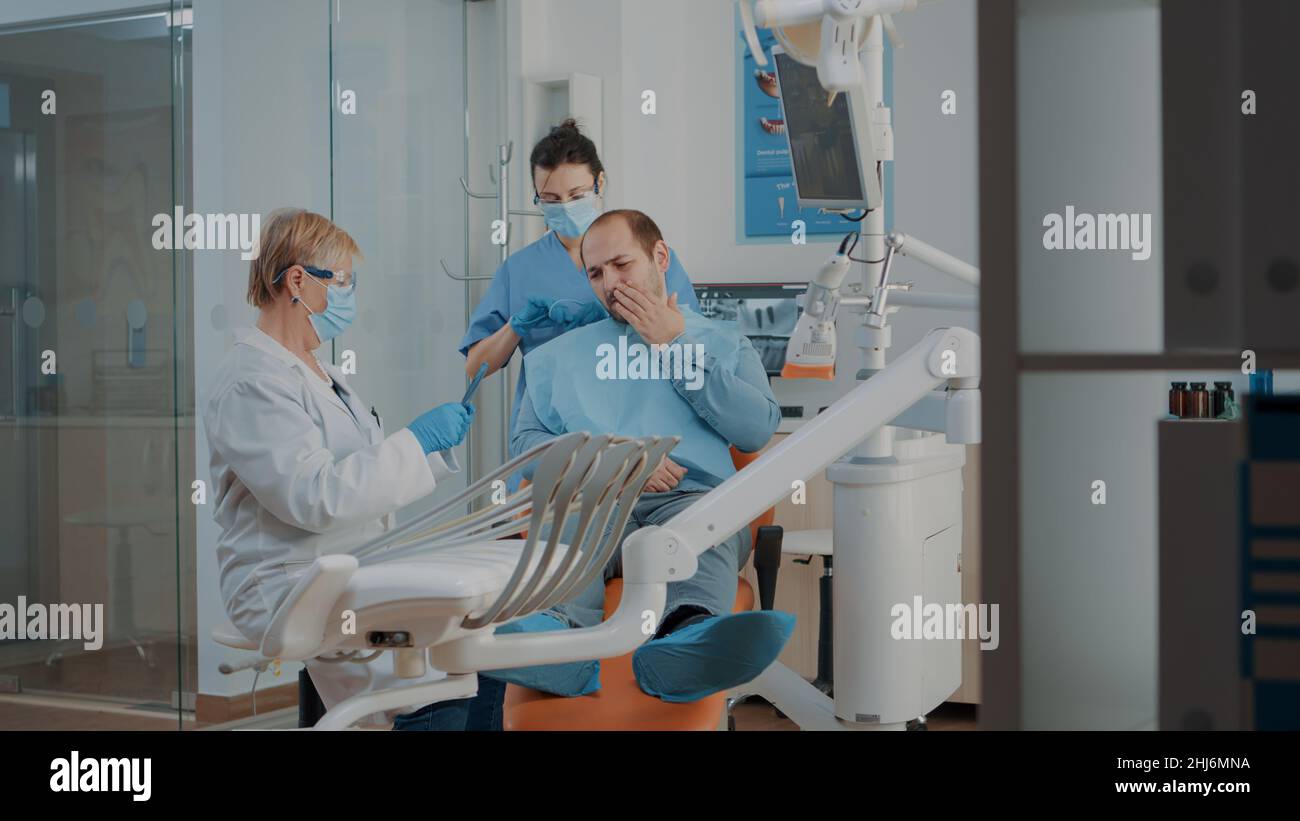 Dentist looking at dental x ray and consulting patient with toothache ...