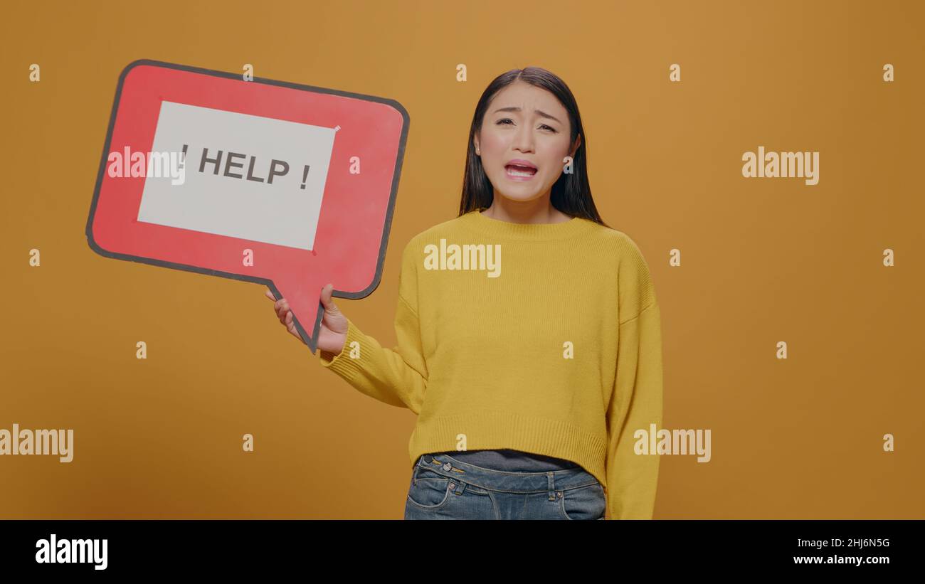 Woman holding speech bubble with text message, asking for help in ...