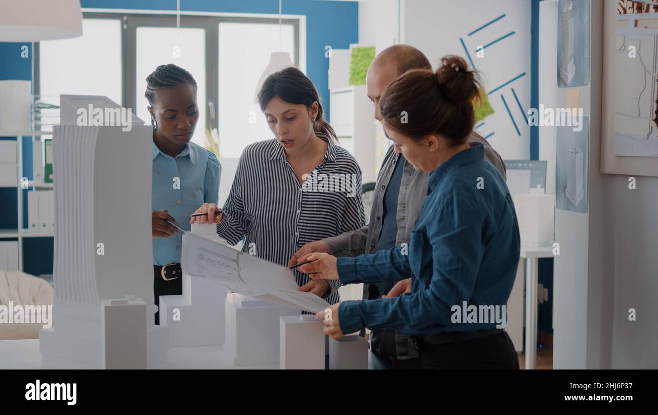 Diverse group of colleagues working on building model design with ...
